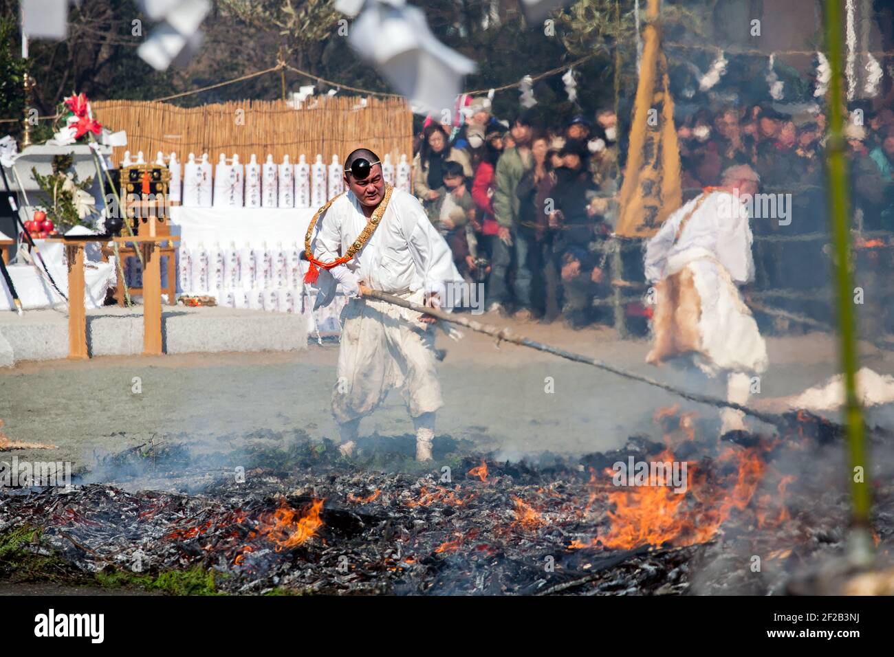 Shugenja Buddhist pilgrims raking the hot coals pyre at the Hiwatari ...