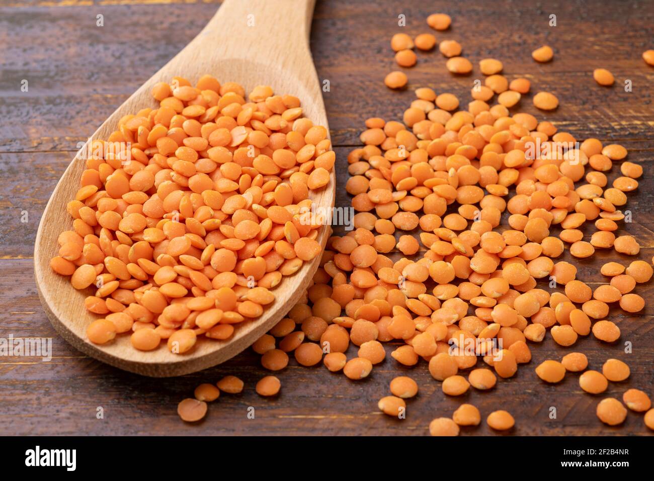 Orange lentil on a spoon over wooden table Stock Photo - Alamy