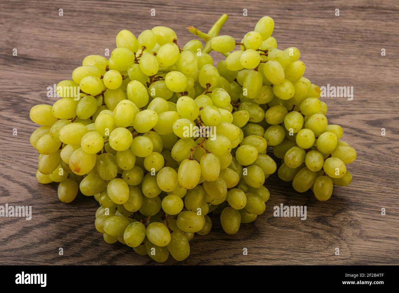 Sweet Green grape branch over background Stock Photo - Alamy