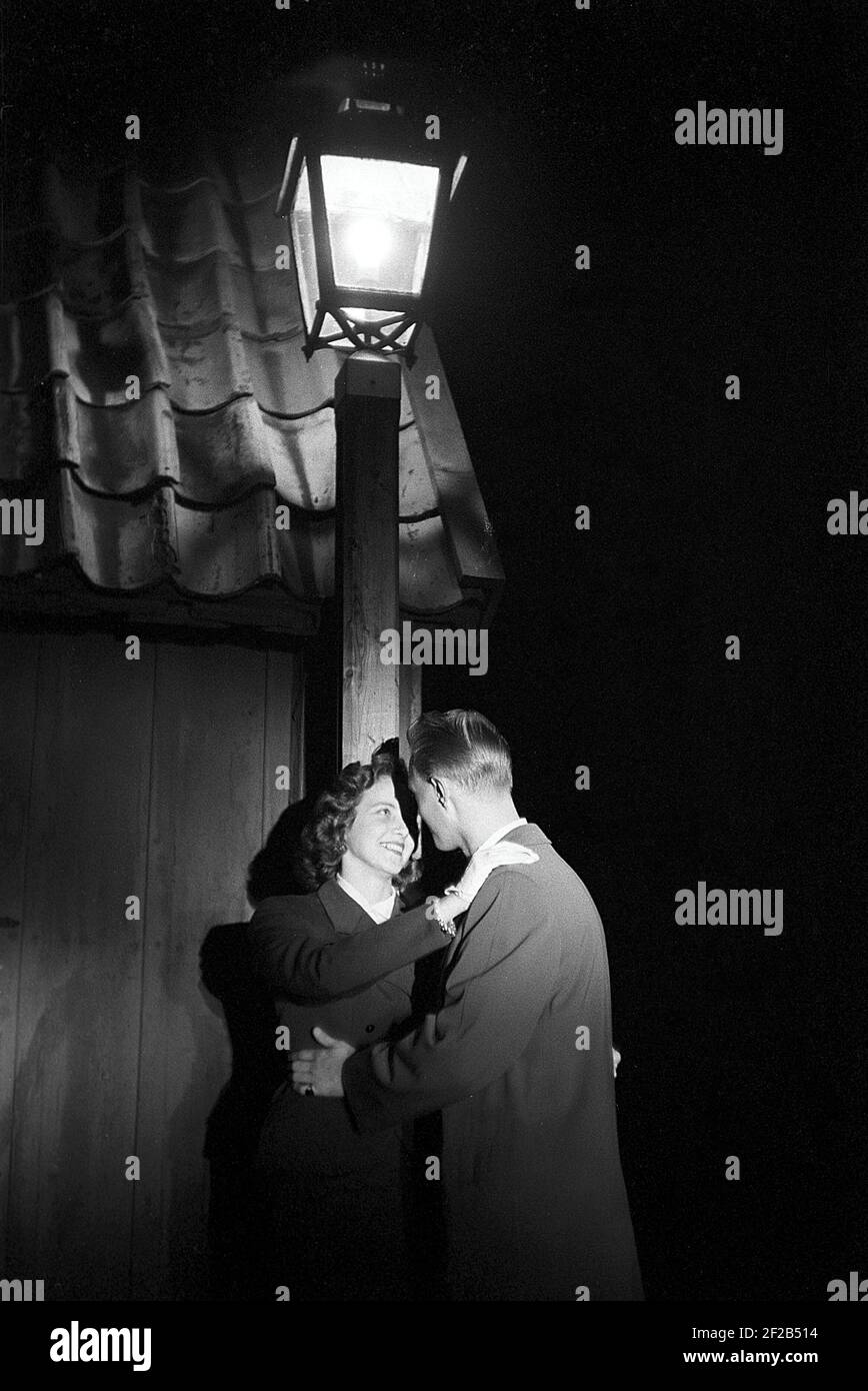 Love in the 1950s. A young couple in the evening are standing under a ...