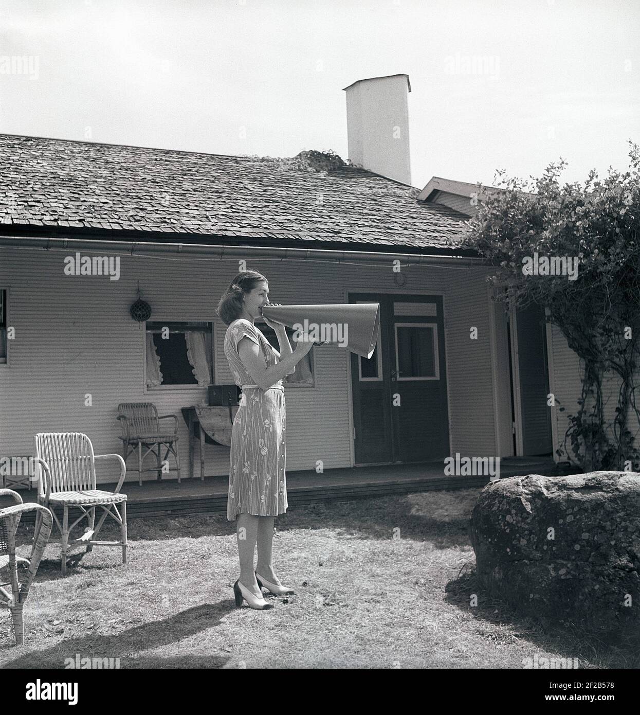 1940s woman. To make herself heard better the young woman is yelling ...