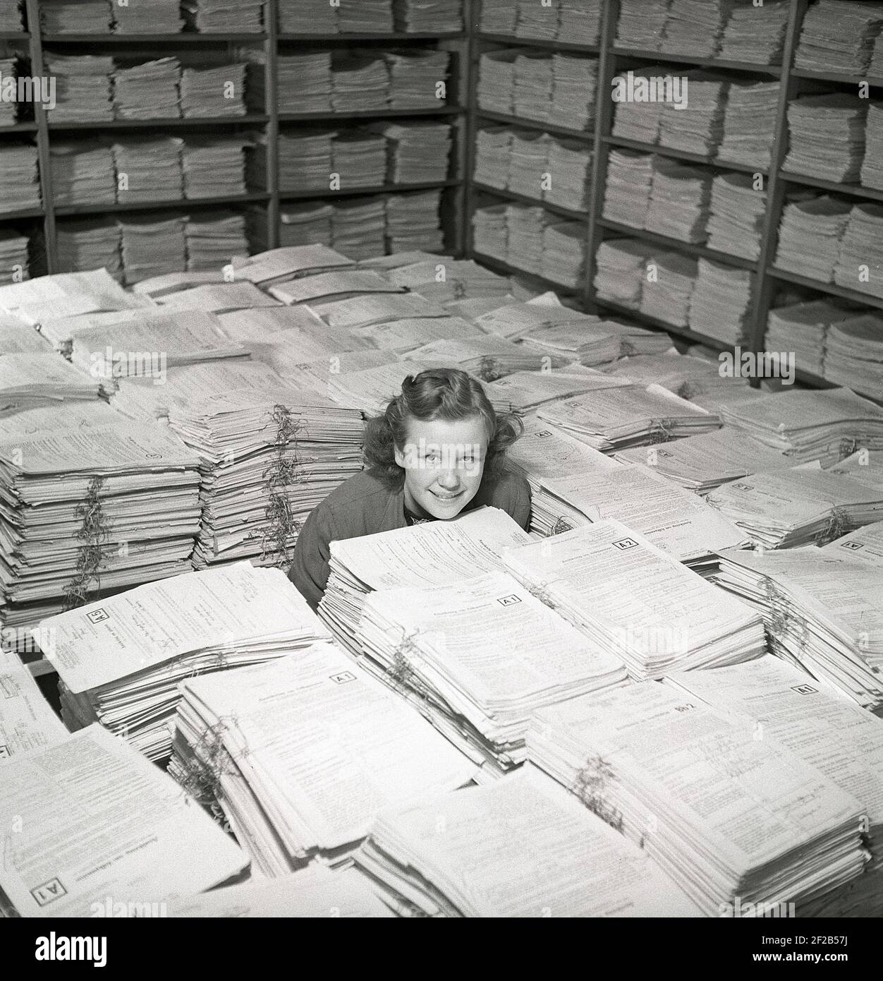 1940s working girl. A young woman in the storage room of thousands and ...