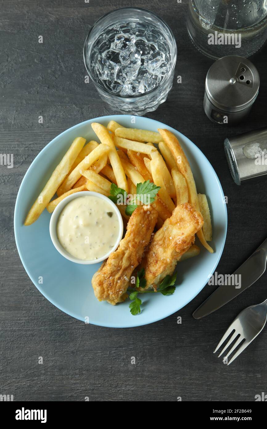 Concept of tasty eating with fried fish and chips on dark textured ...