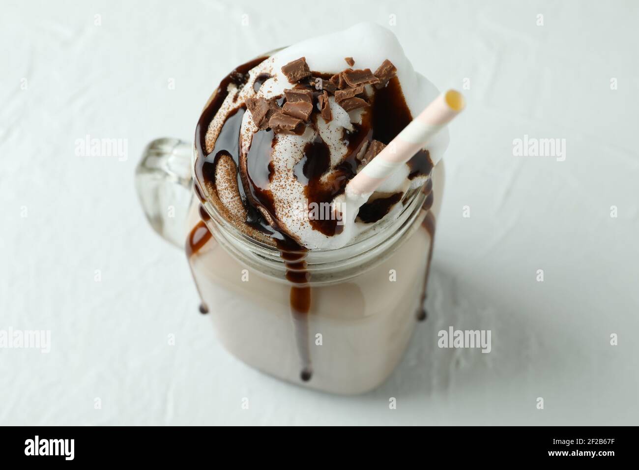 Glass of chocolate milkshake on white textured table Stock Photo - Alamy