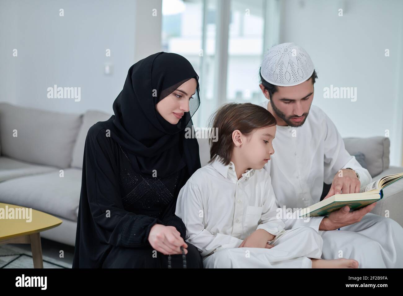 Young muslim family reading Quran during Ramadan Stock Photo - Alamy