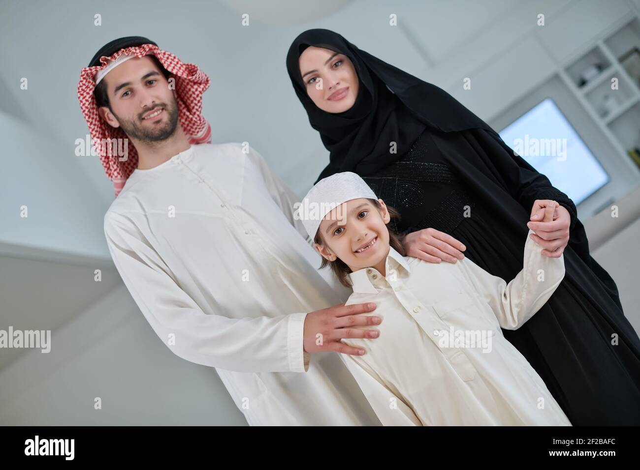 Portrait of young arabian muslim family wearing traditional clothes ...