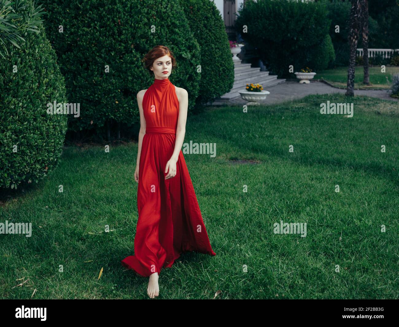 Pretty woman red dress walking luxury model outdoors Stock Photo - Alamy