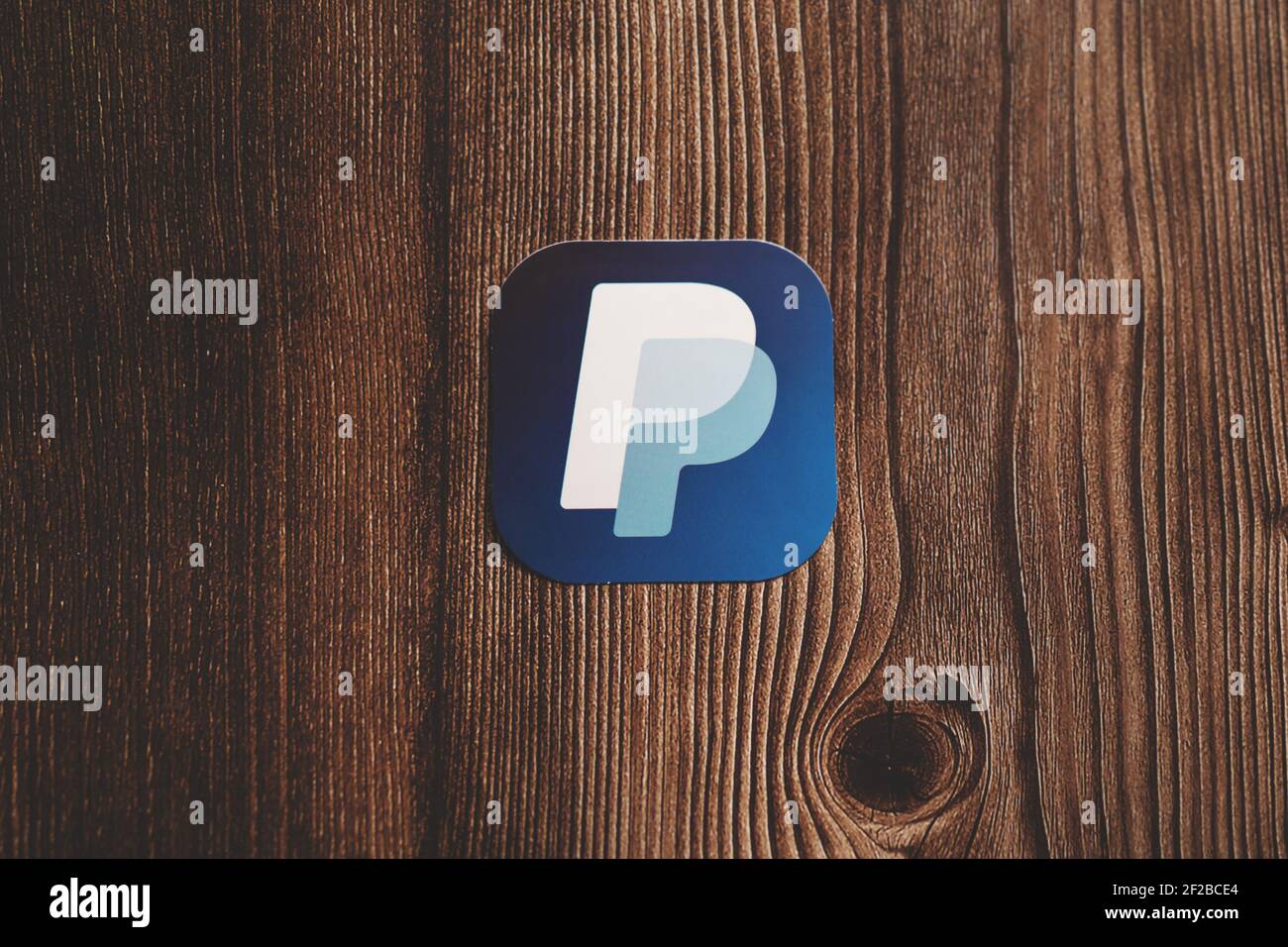 Paypal app blue logo printed on paper centrally placed on wooden ...