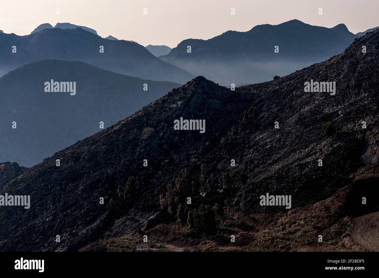 Mist gathers in steep-sided valleys as the setting sun throws details ...