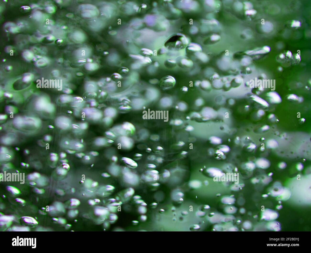 Green abstract background - boiling water in a glass pot, Bubbles and ...