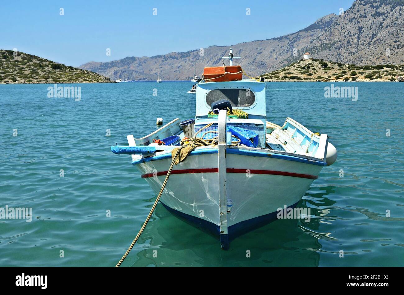 Traditional wooden Greek fishing boat on the waters of Symi island in ...