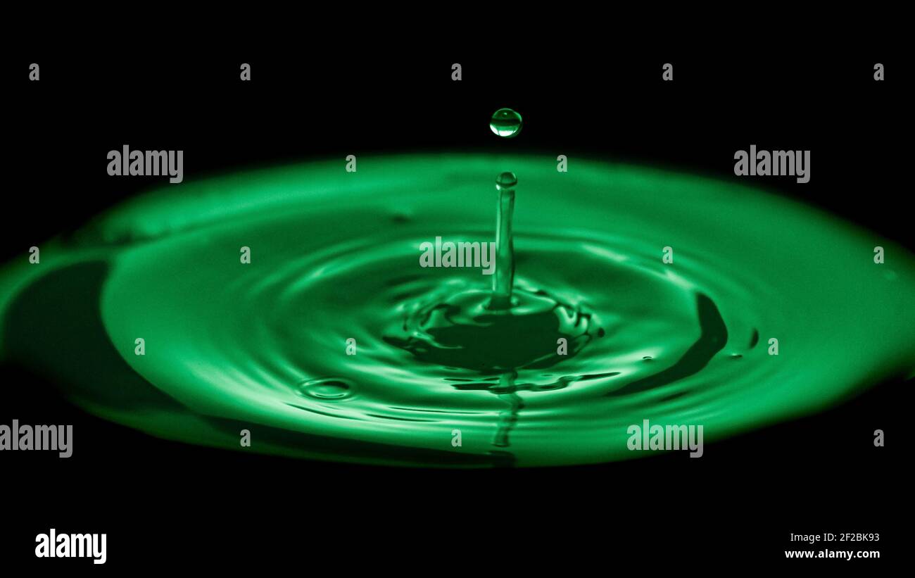 A water drop ripp on green background Stock Photo - Alamy