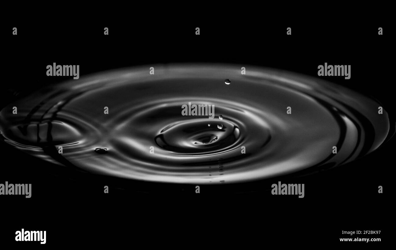A water drop ripple on black background Stock Photo - Alamy
