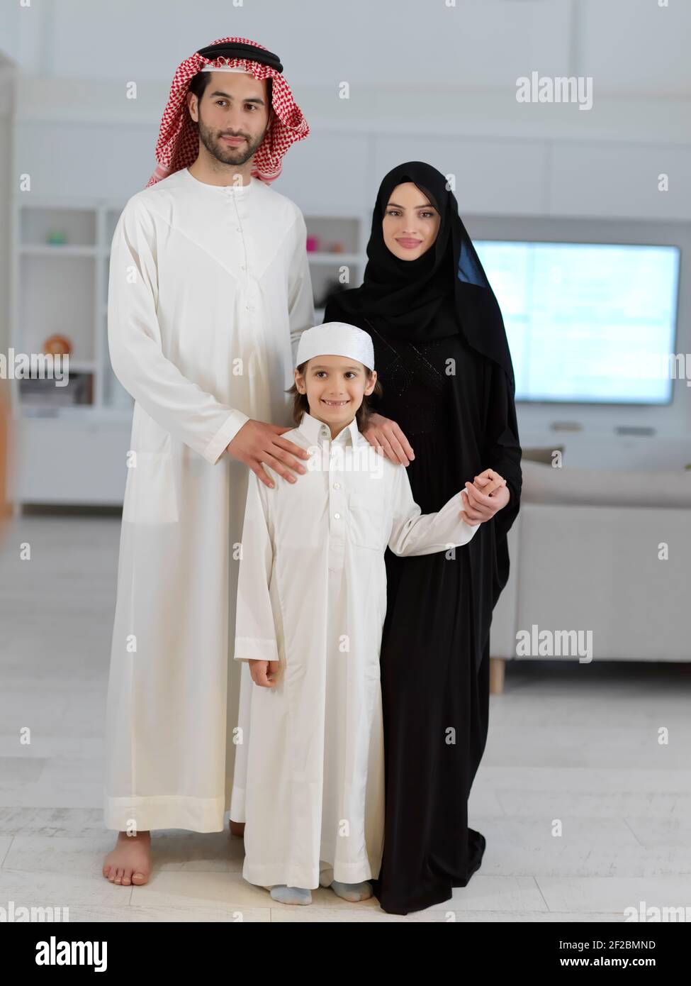 young arabian muslim family wearing traditional clothes at their modern ...