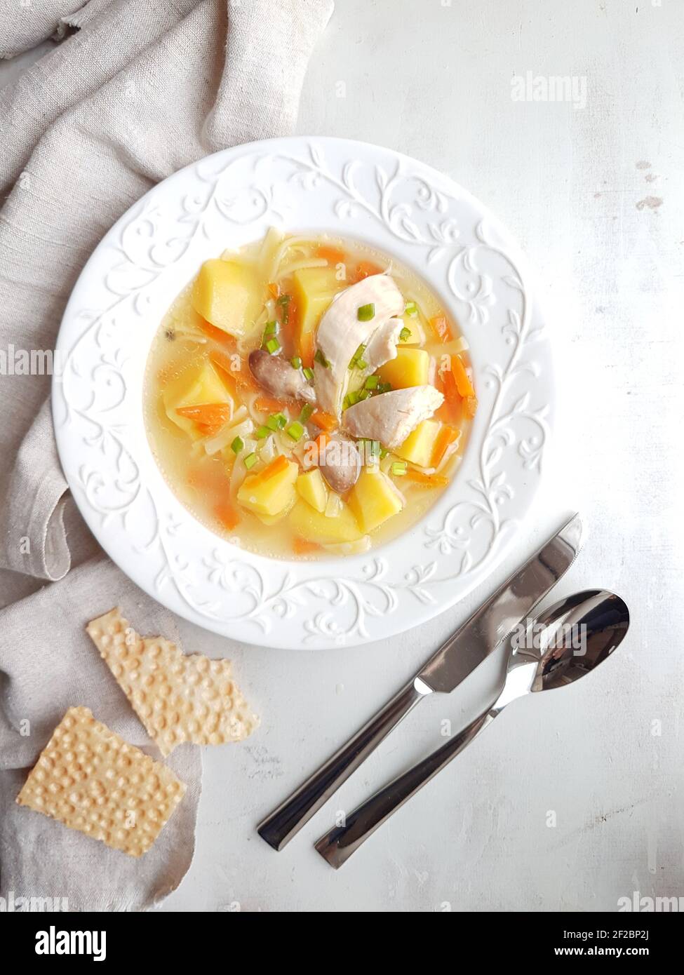 Soup with chicken, noodles and mushrooms on a white plate Stock Photo ...