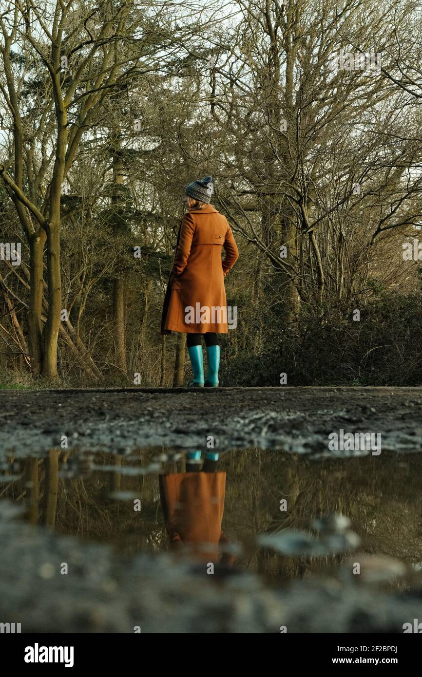 Winter reflection of woman in puddle Stock Photo - Alamy