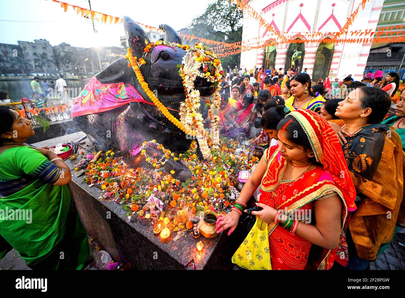 A Hindu woman seen offering prayers with milk & water on the idol of ...