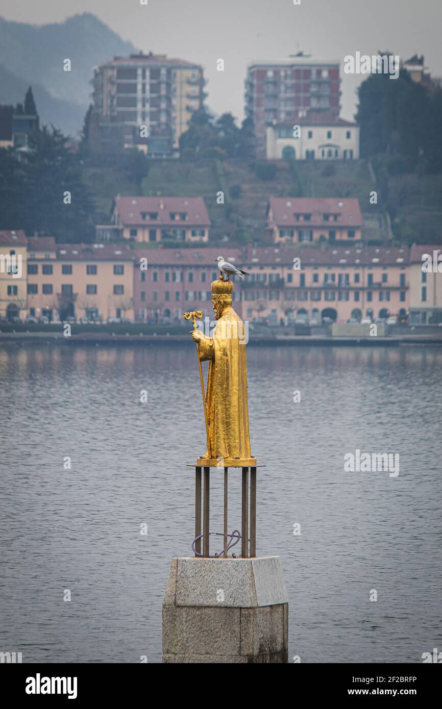 A golden statue placed in the middle of the lake in Lecco, near Como ...