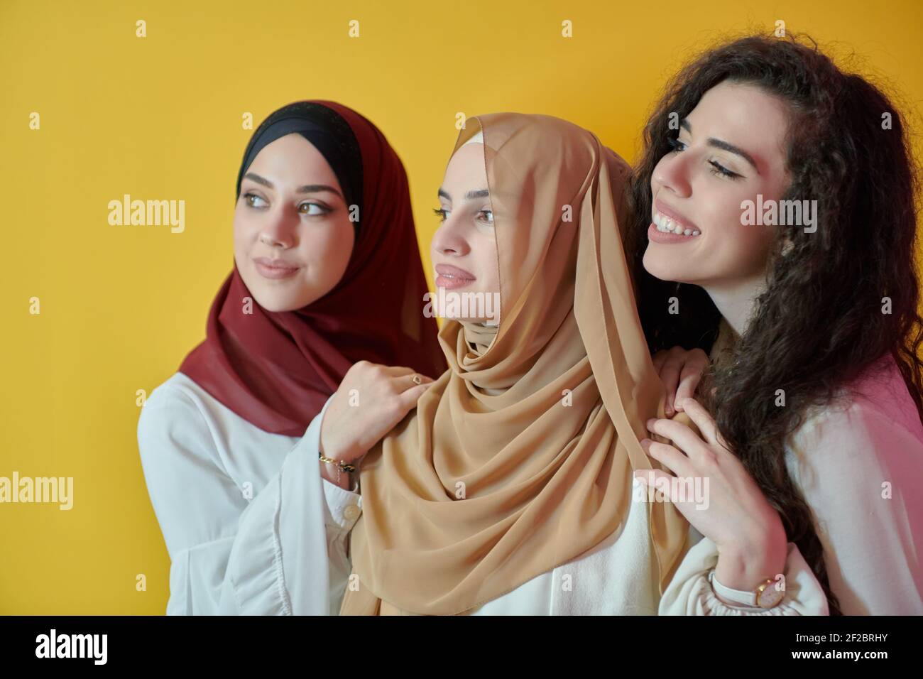 Young muslim women posing on yellow background Stock Photo - Alamy