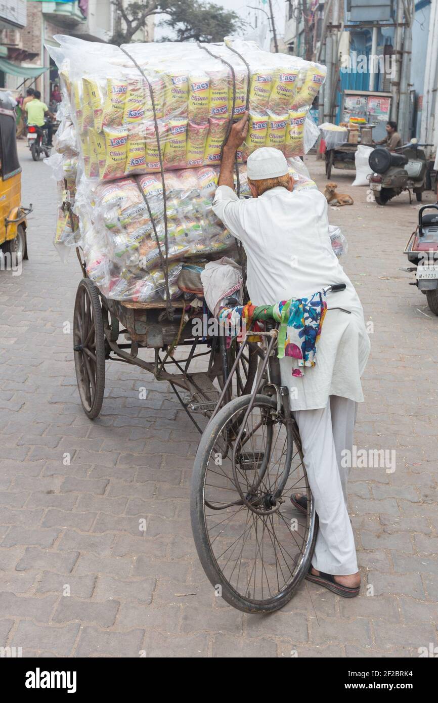 India, Mathura - Man loading cargo onto bicycle to delver Stock Photo ...