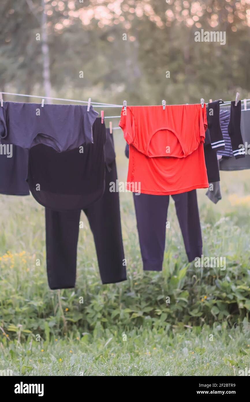Colorful clothes and laundry hanging on a clothesline in country yard ...