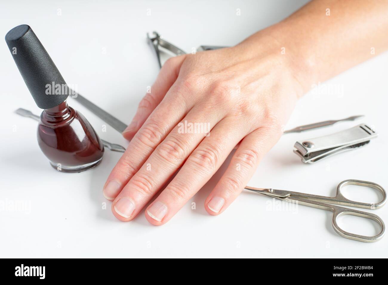 Manicure tools and female hand on white background. Making self ...