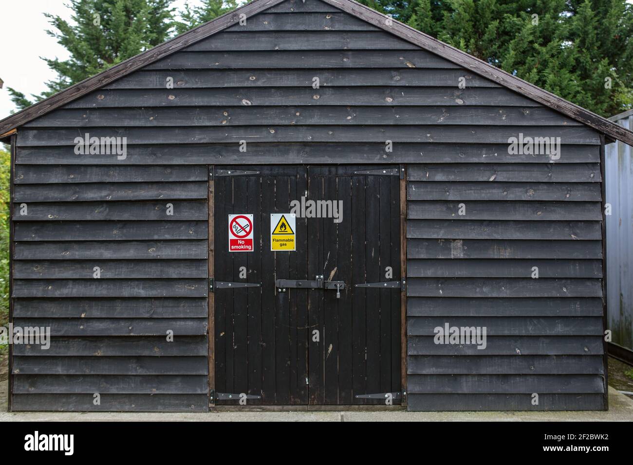Flammable and no smoking sign on the doors on a large wooden shed Stock ...