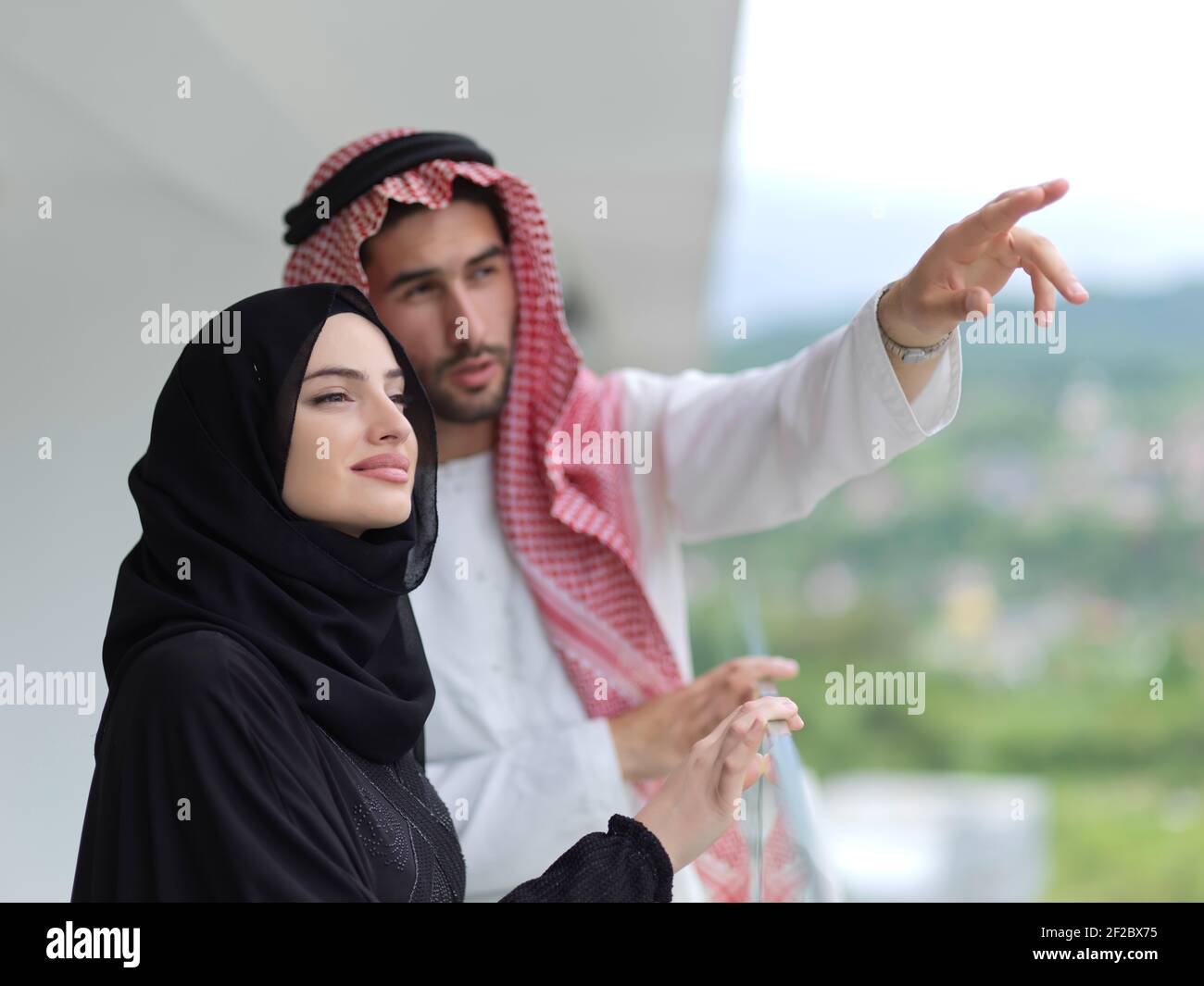 Portrait of young muslim couple on balcony. Married arabians in ...
