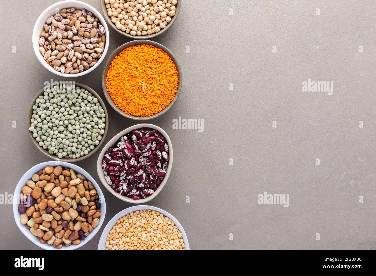 Different types of legumes in bowls, green and yellow peas, chickpeas ...