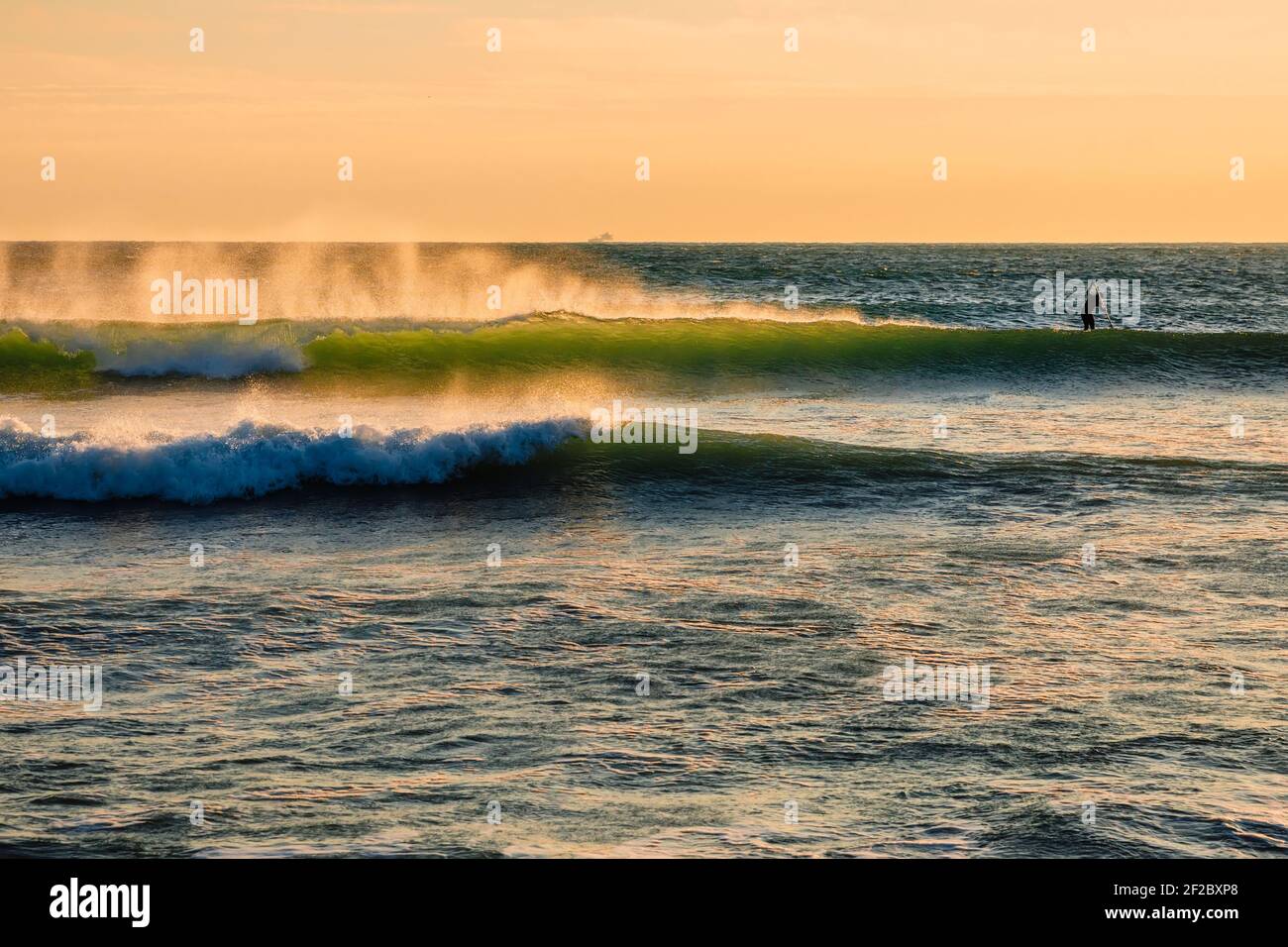 Ocean waves at warm sunset or sunrise. Waves and strong wind with ...