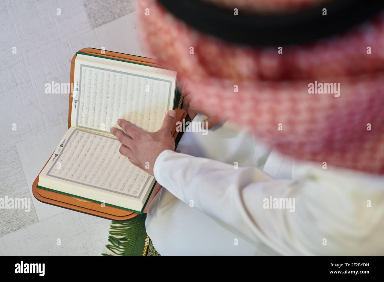 Young muslim man reading Quran during Ramadan Stock Photo - Alamy