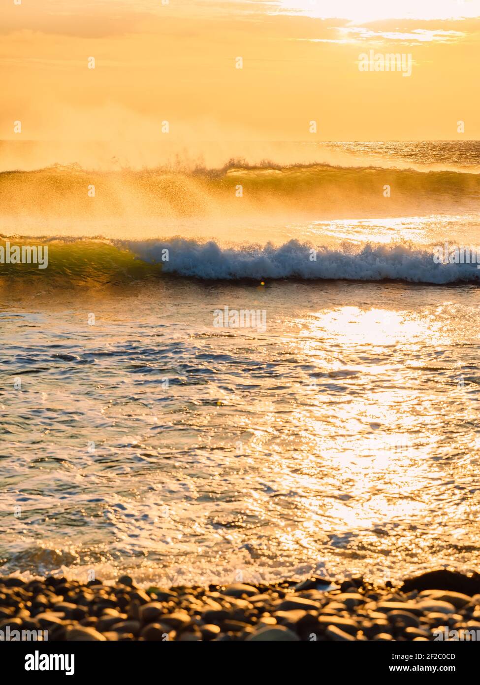 Ocean waves at warm sunset or sunrise. Waves and strong wind with ...