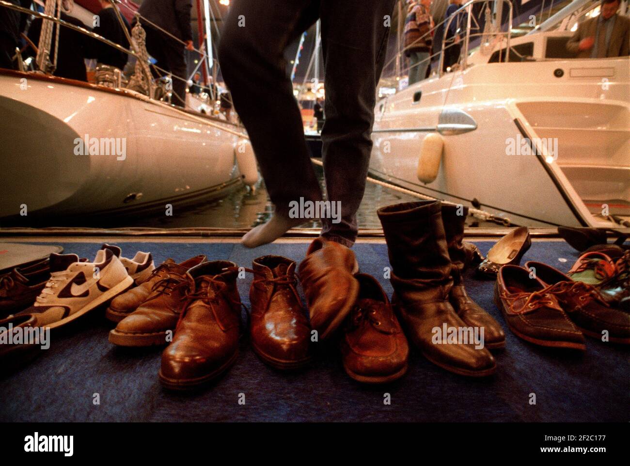 VISITORS AT THE BOAT SHOW TAKE OFF THEIR SHOESTO BOARD EXHIBITED BOATS ...