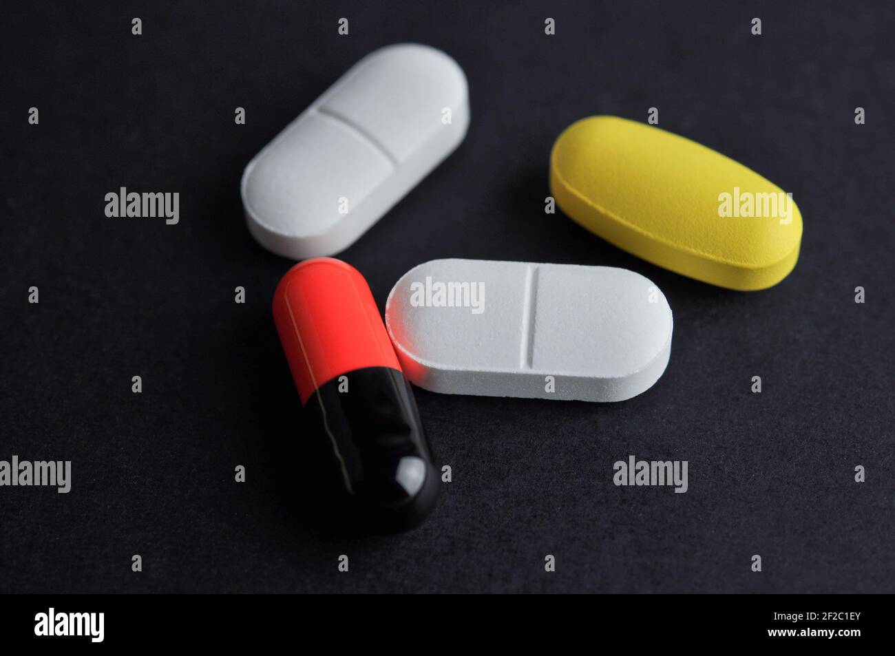 Tablets and capsule on black background. Medication concept Stock Photo ...