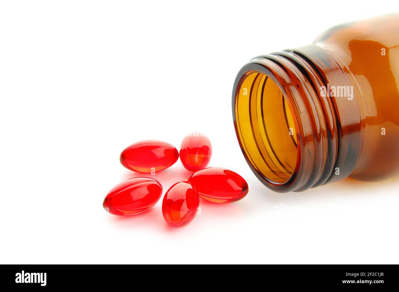 Red vitamin pills in vial isolated on white background Stock Photo - Alamy