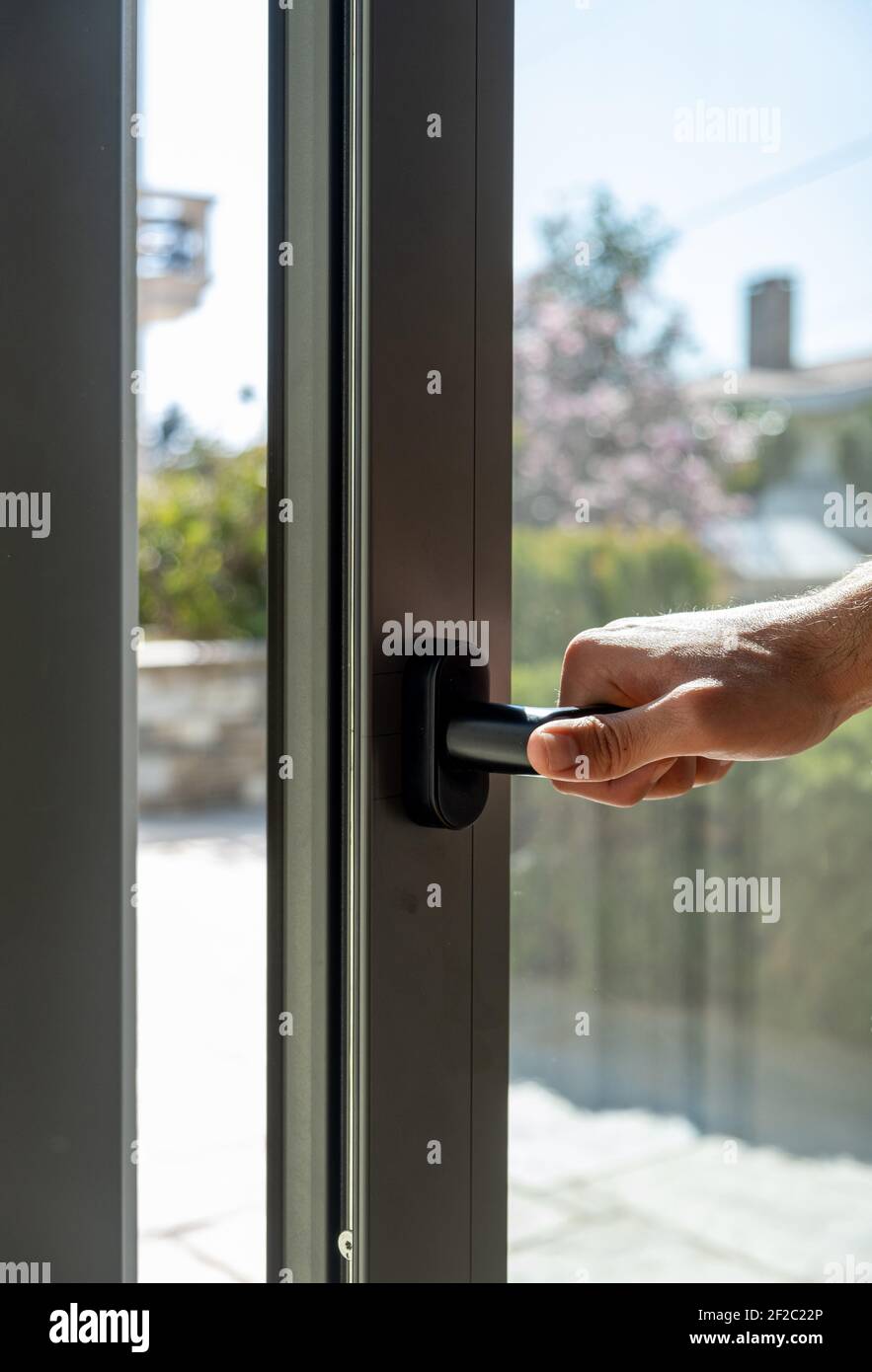 Male hand open aluminum window frame closeup view. Man holding the ...