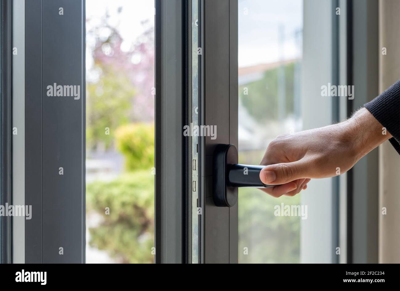Open the window. Hand and aluminum frame closeup view. Man holding the ...