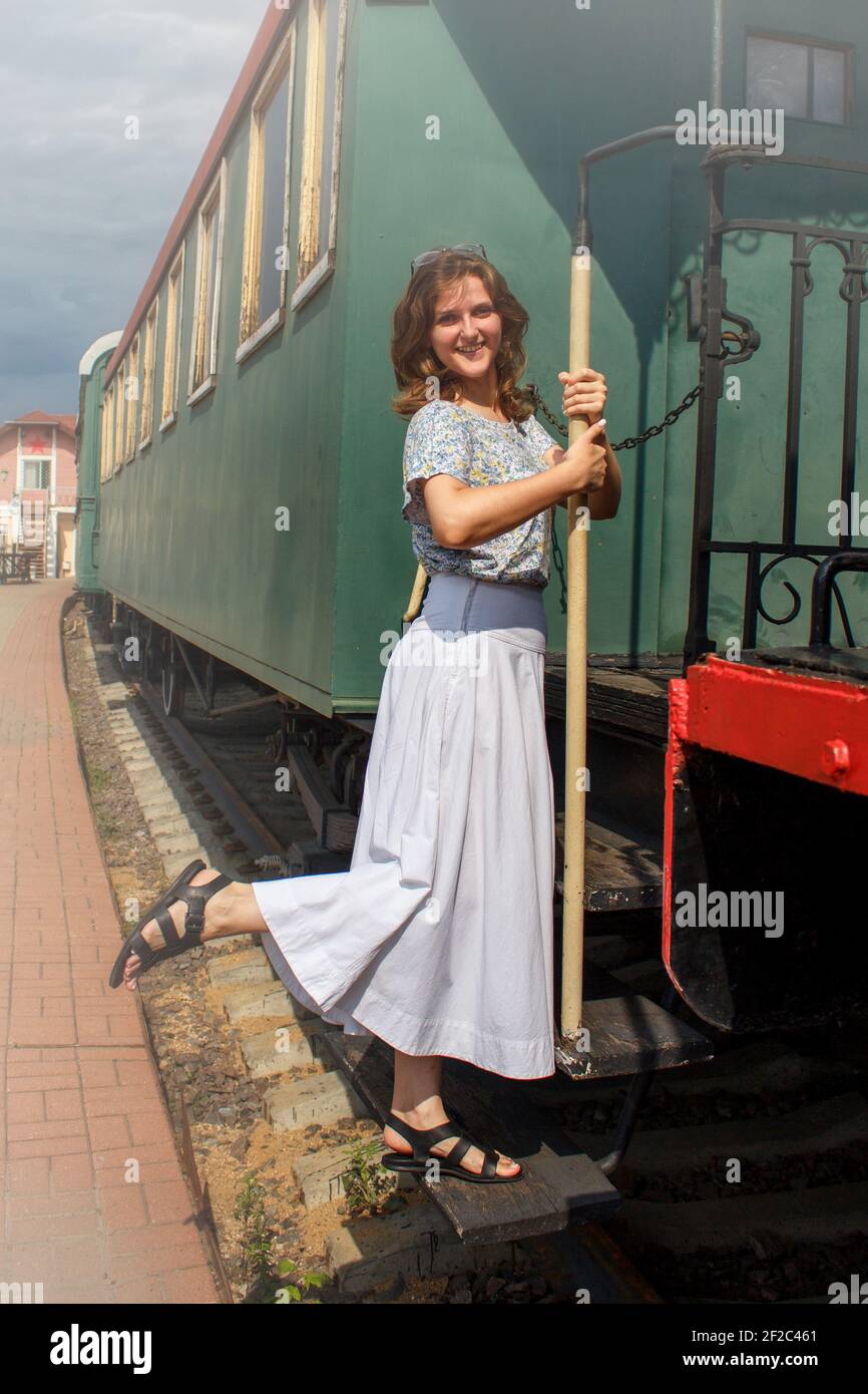 A young woman sits in the departing retro train Vintage cars in the ...