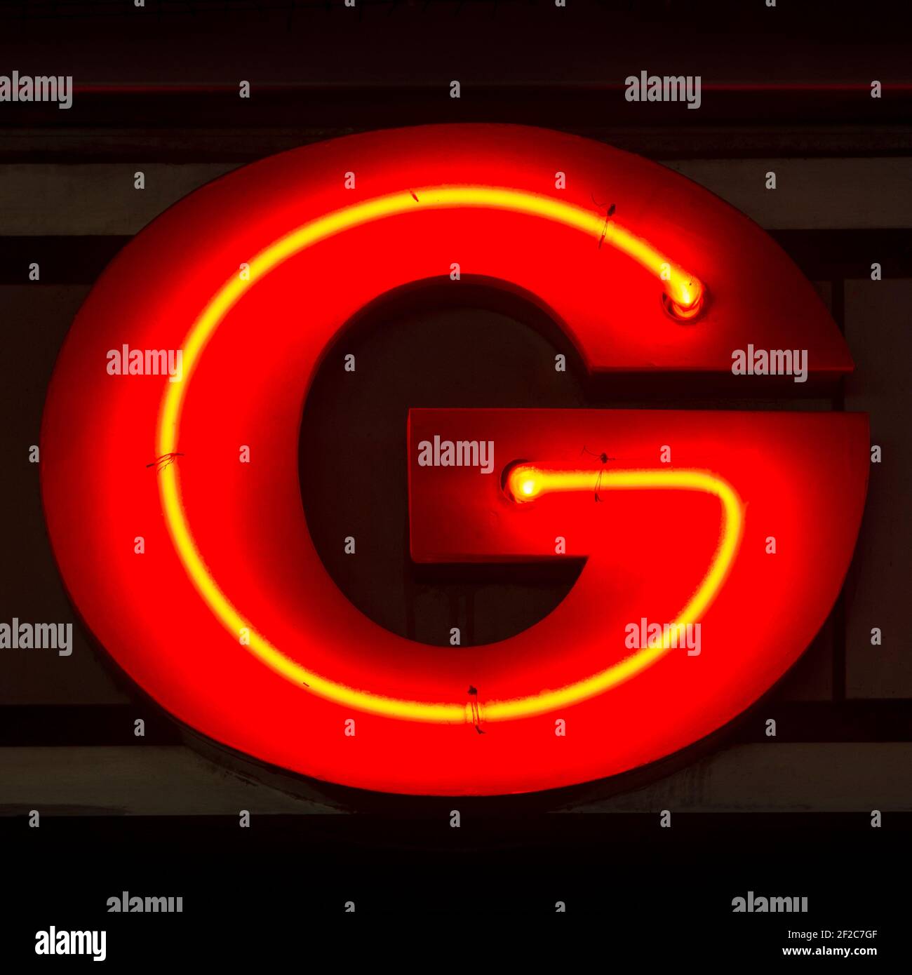 Red glowing neon letter G at night Stock Photo - Alamy