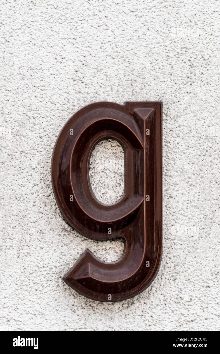 Dark brown glazed letter g on a light wall Stock Photo - Alamy