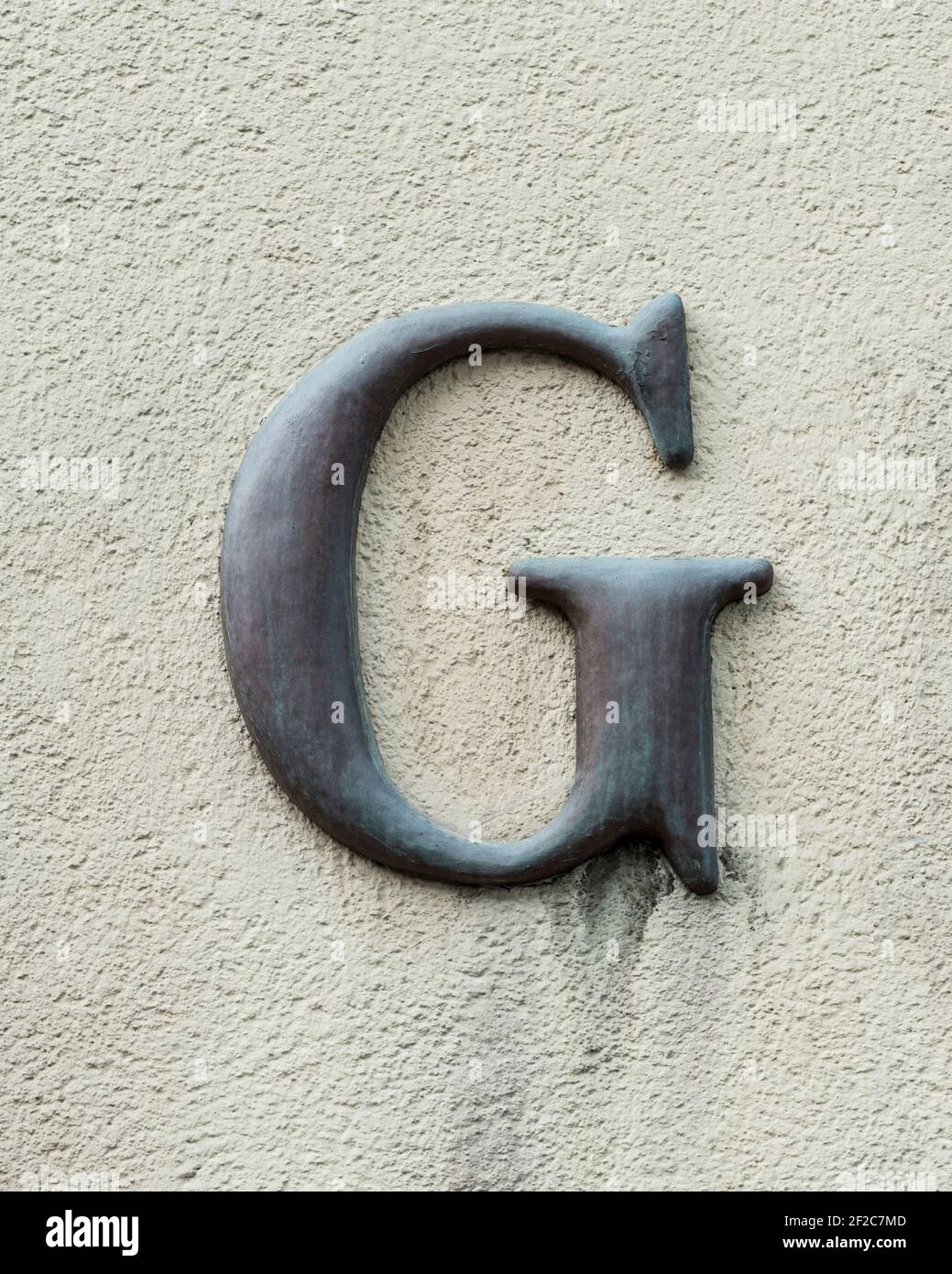 Metal letter G on a house wall Stock Photo - Alamy