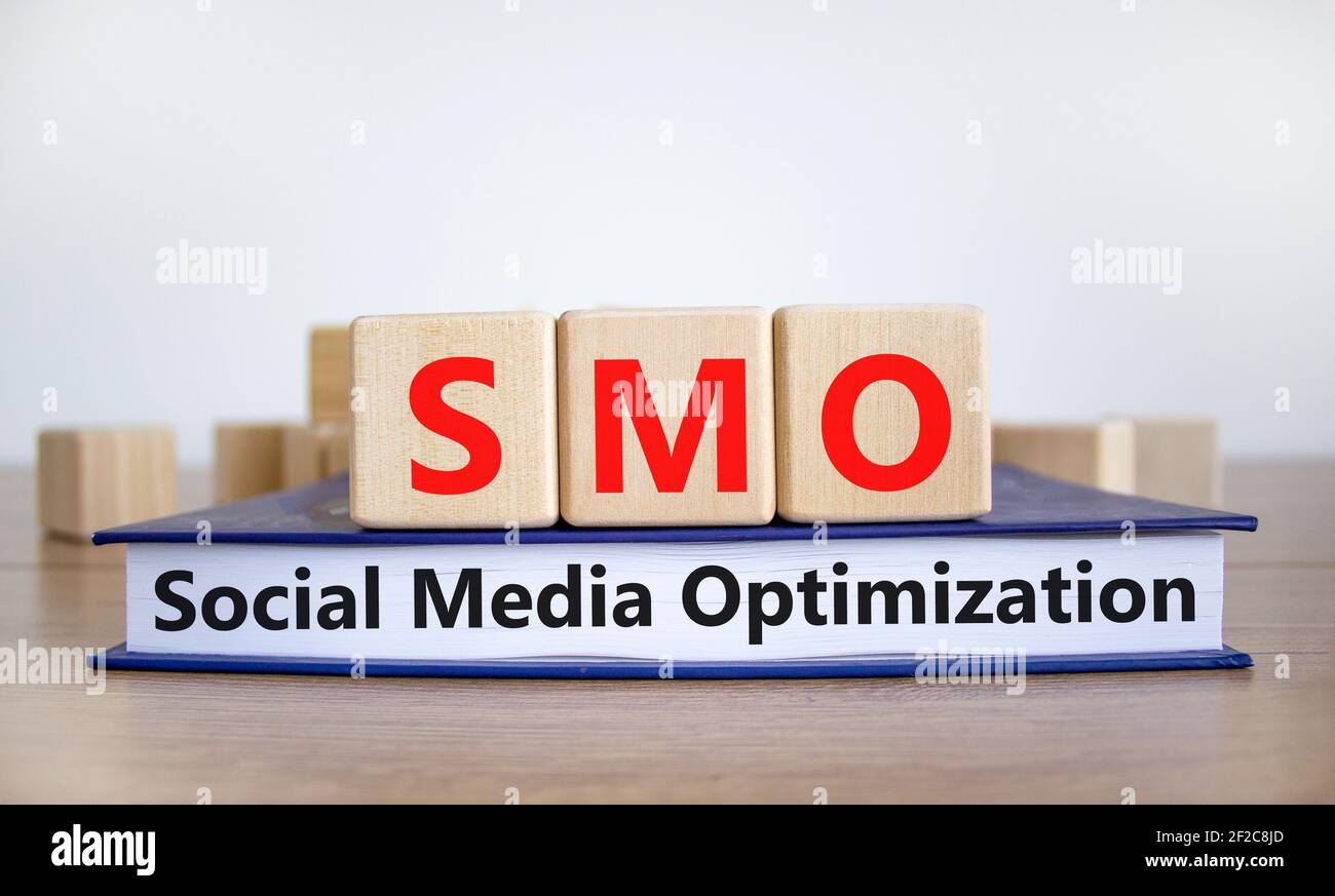 SMO, social media optimization symbol. Wooden cubes on book with word ...