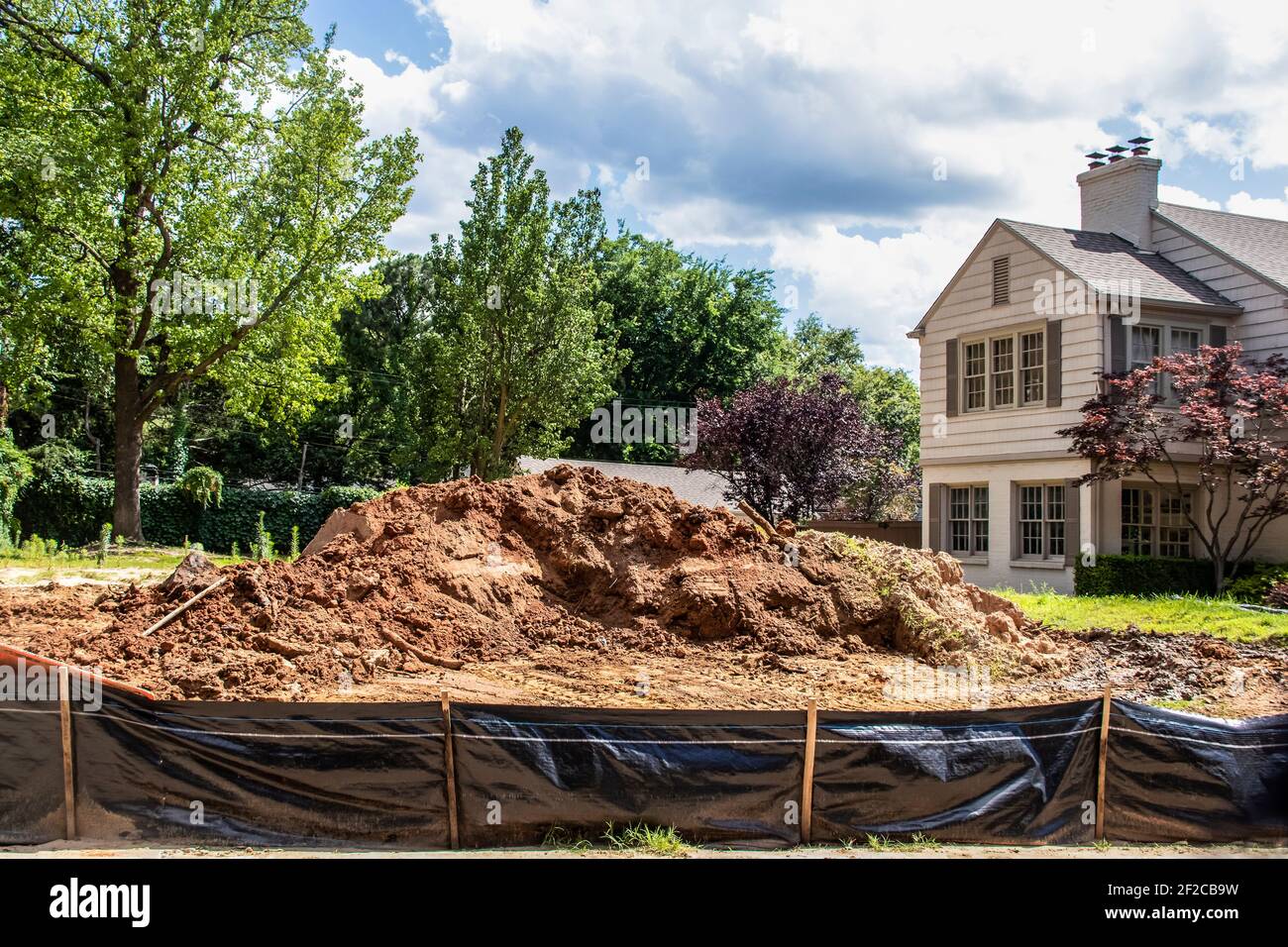Construction - Pile of dirt in vacant lot behind black plastic fence in ...