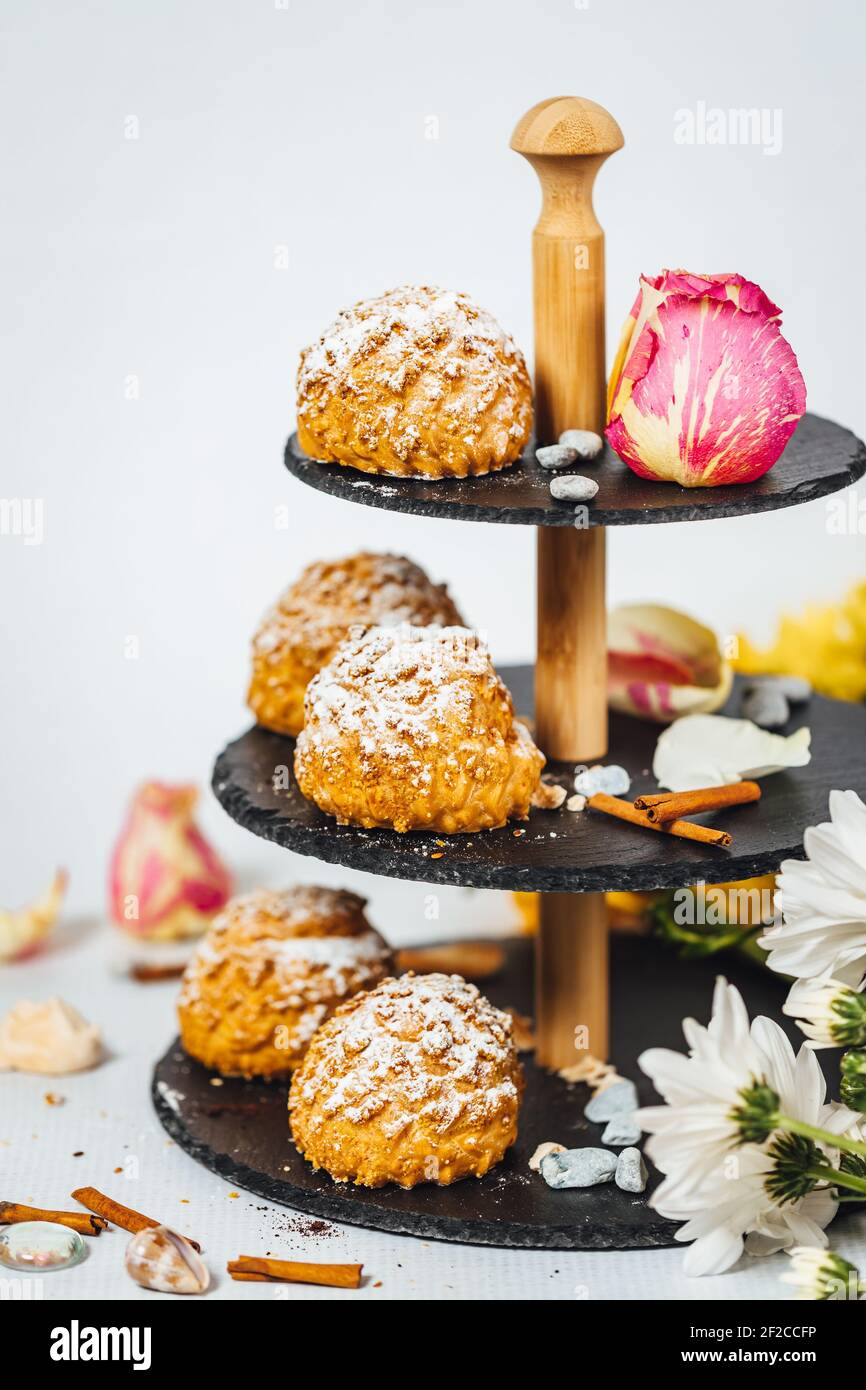 A vertical shot of various types of cakes and biscuits on a cake stand ...