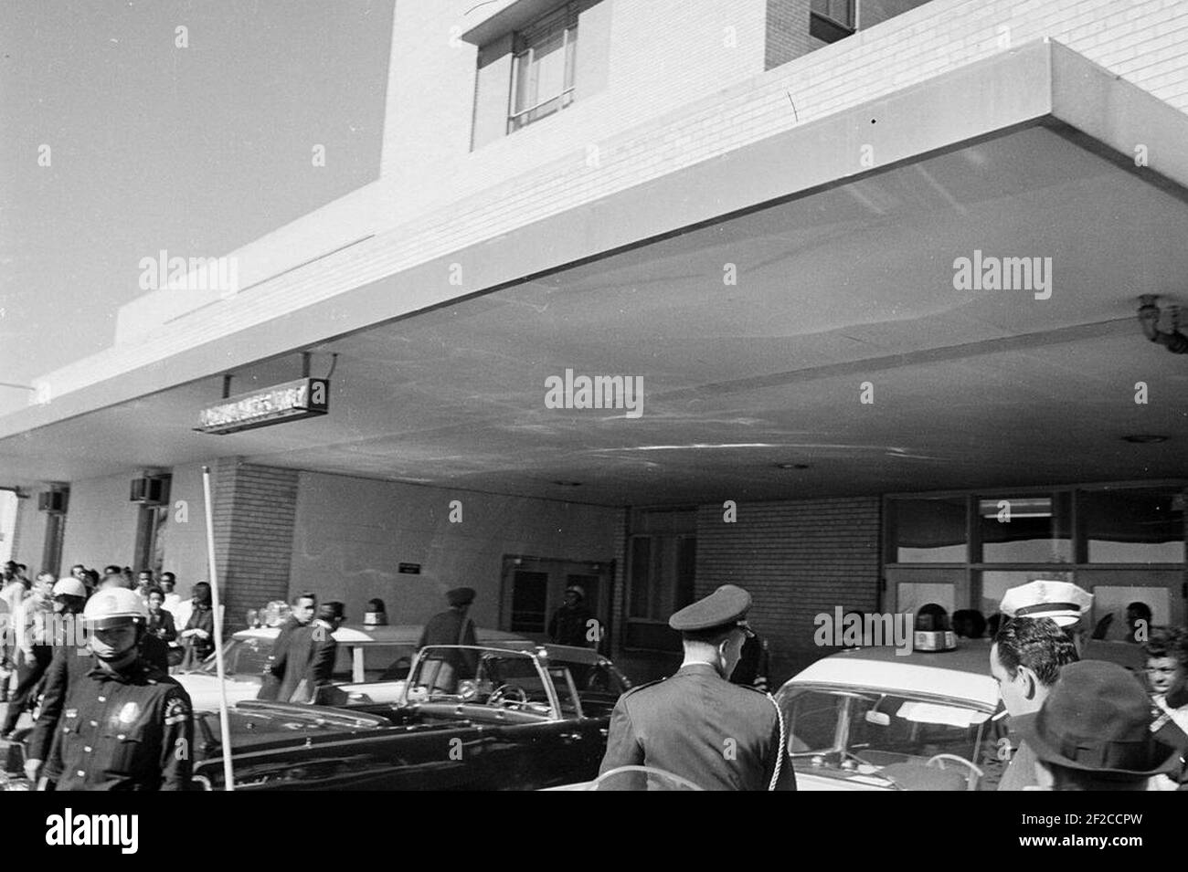 Police officers gather around the Presidential limousine in front of ...