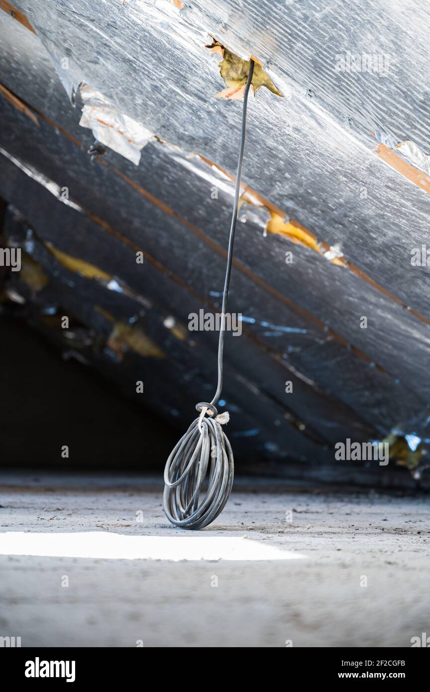 A vertical shot of electric wires hanging from the wall Stock Photo - Alamy
