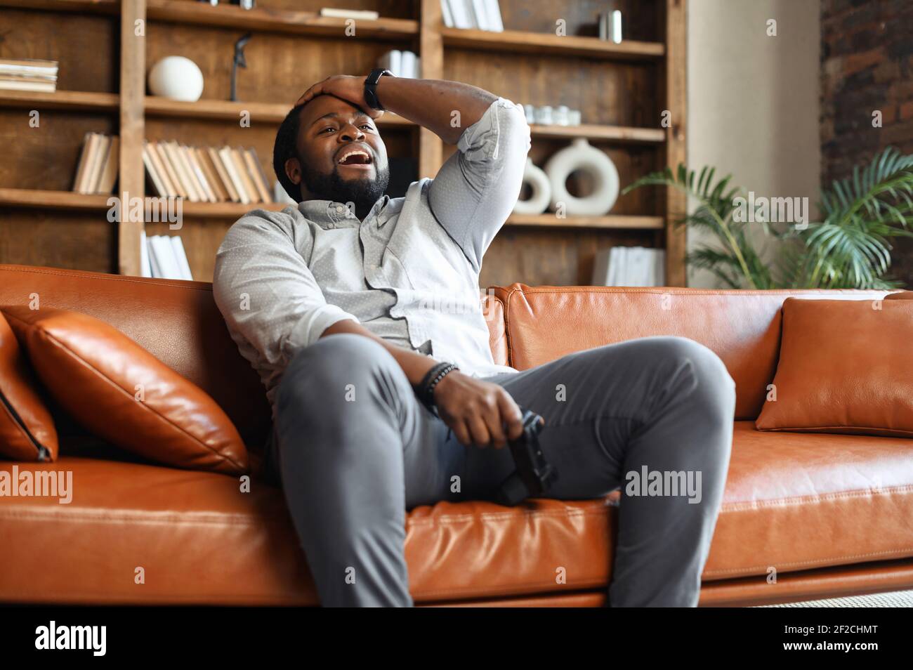 Frustrated African-American guy lost in video game, a young man sitting ...