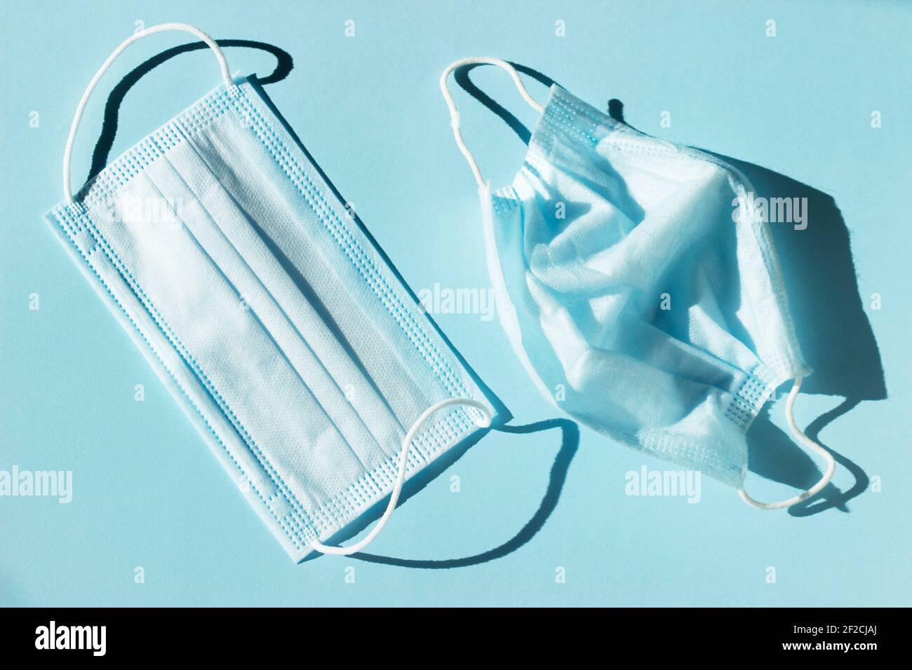 New and used protective medical masks on a blue background Stock Photo ...