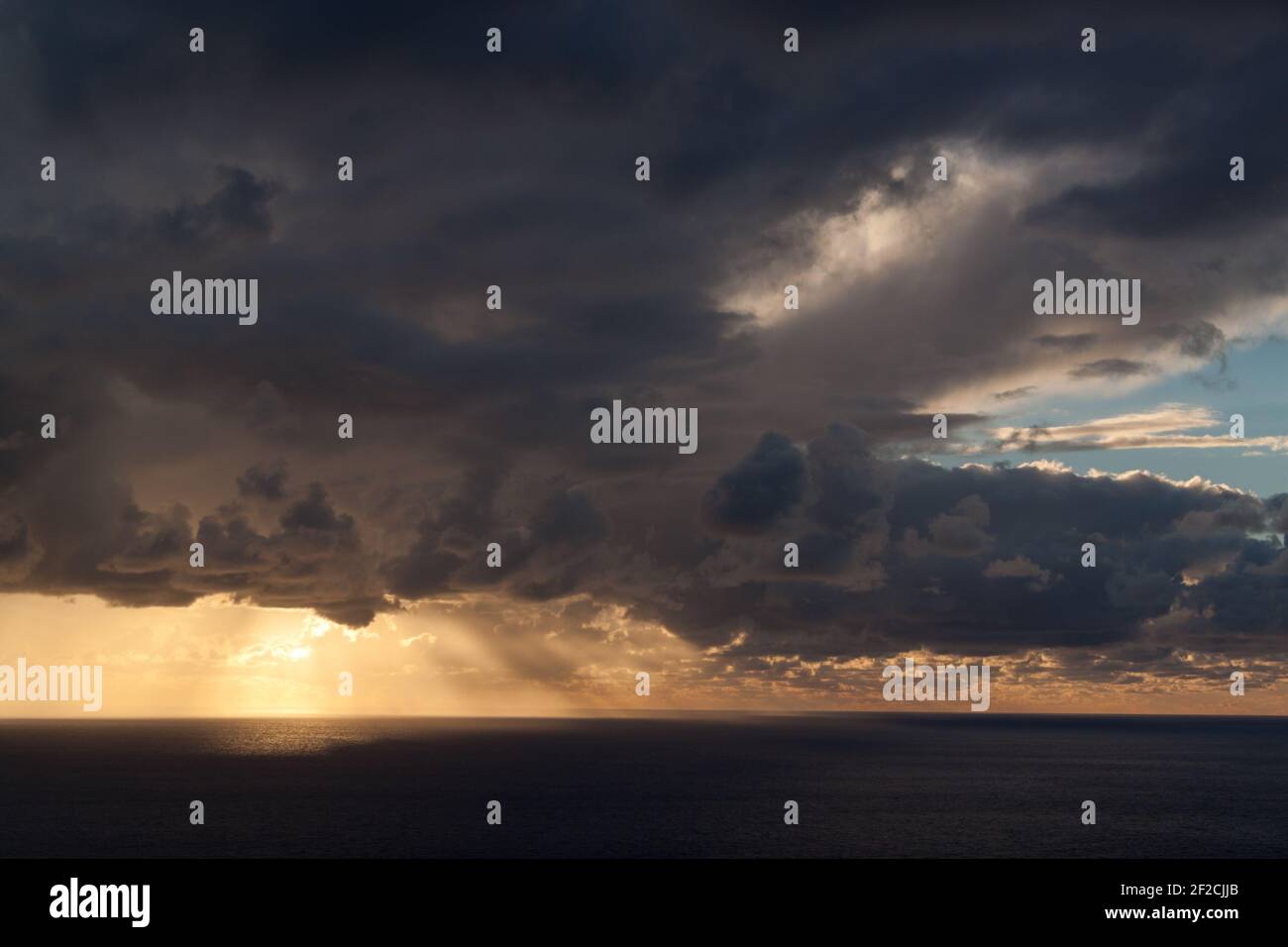 Dramatic sunset with god rays breaking through the clouds over the ...