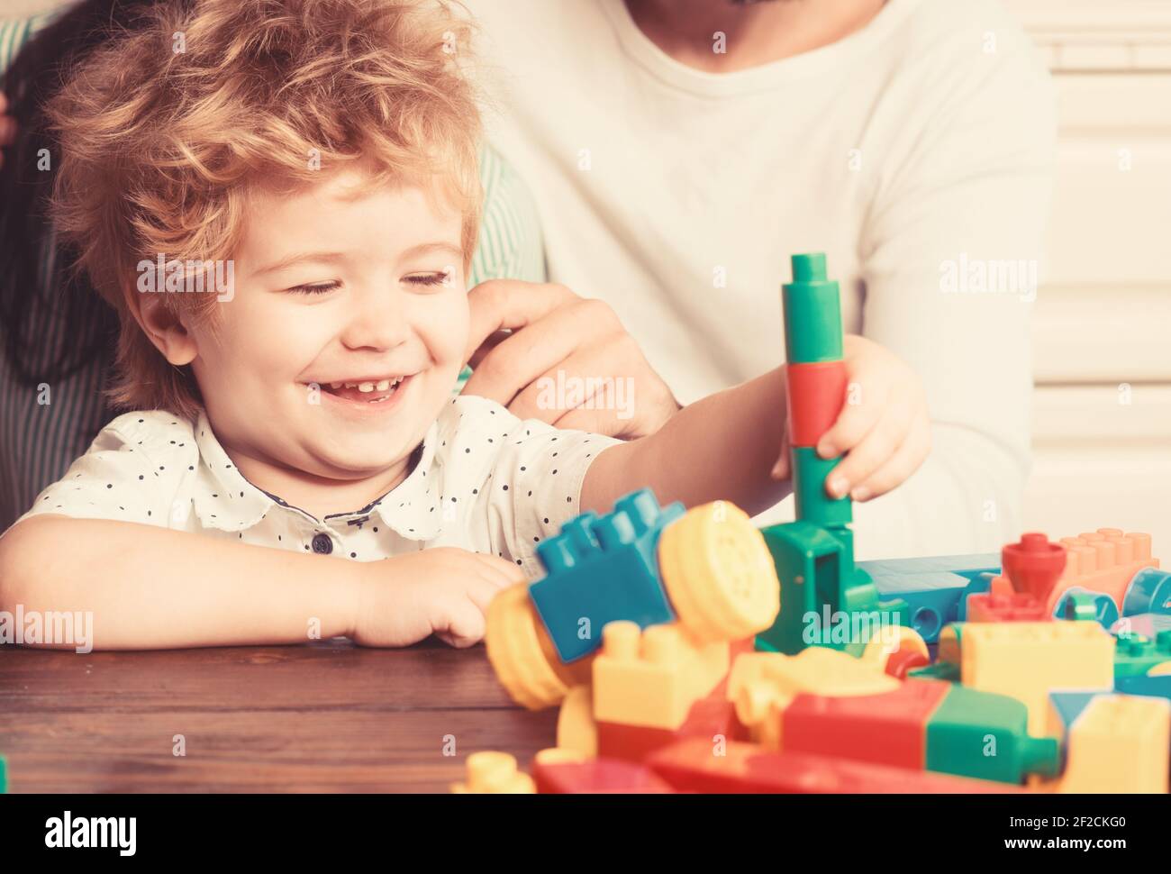 Baby boy looks at toy construction made out of colorful blocks. Kid ...